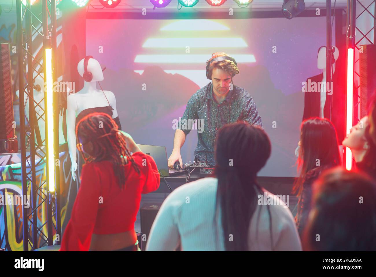 Man dj performing using electronic music mixer and laptop on stage in ...