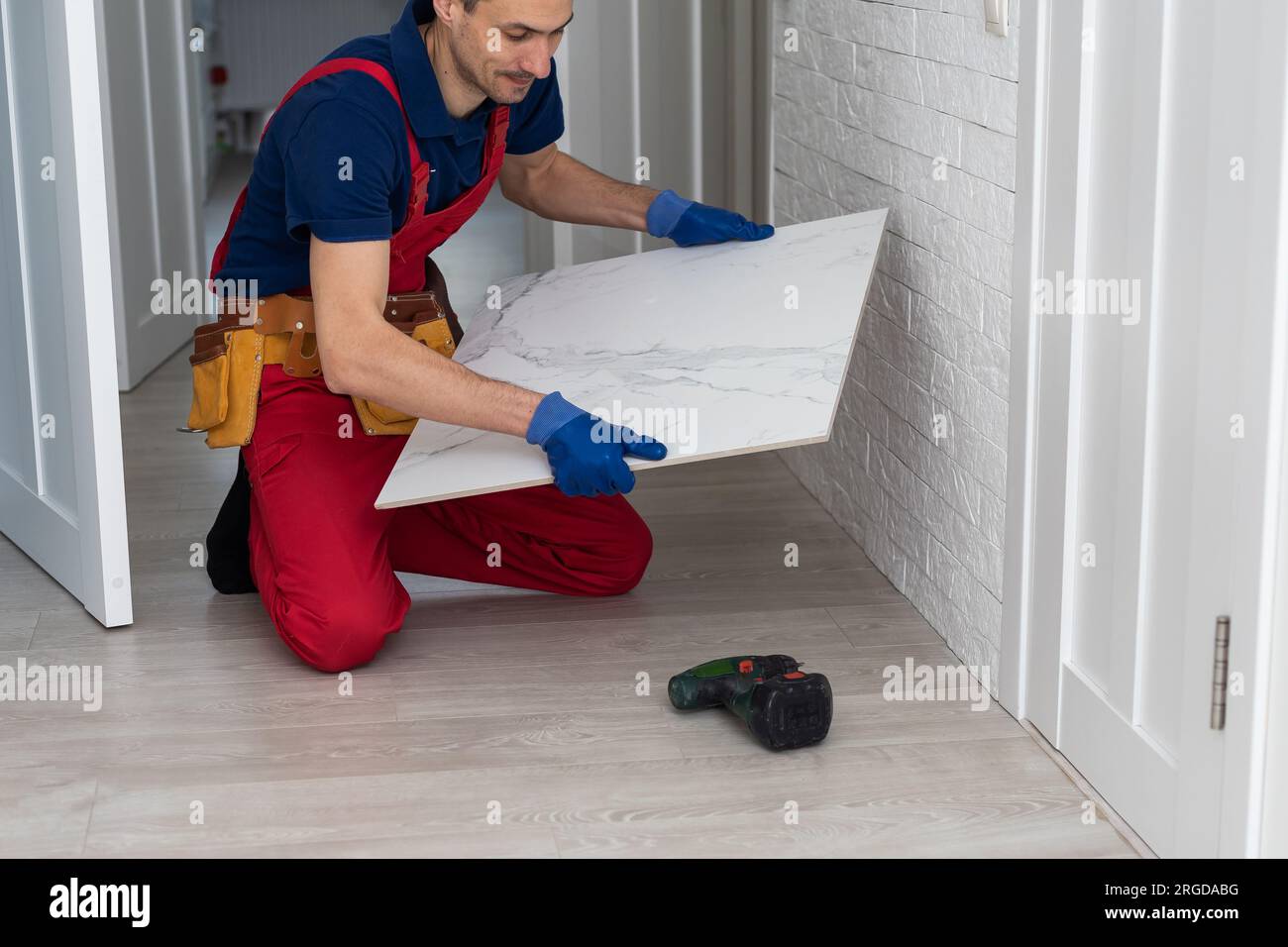 Worker checking level laying tiles hi-res stock photography and images ...