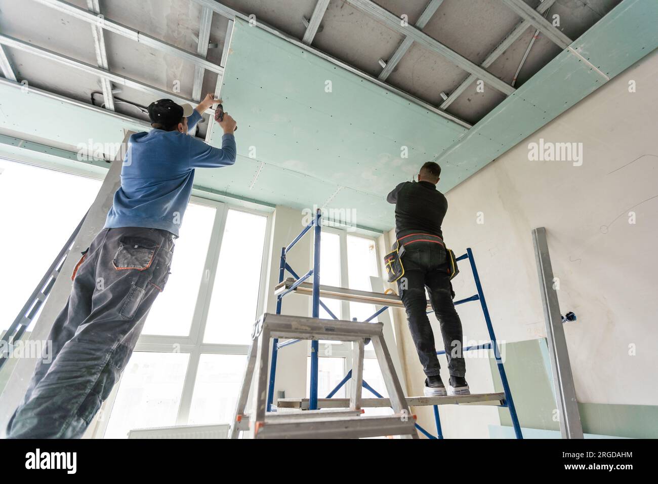 Workers fitting panel into frame of ceiling Stock Photo - Alamy