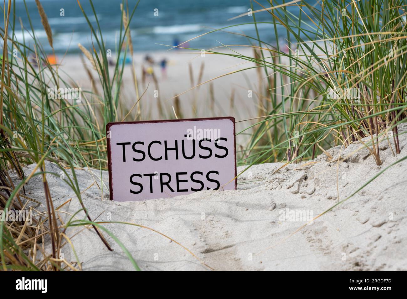 The German text 'Tschuess Stress' (goodbye stress) in the sand dunes at ...