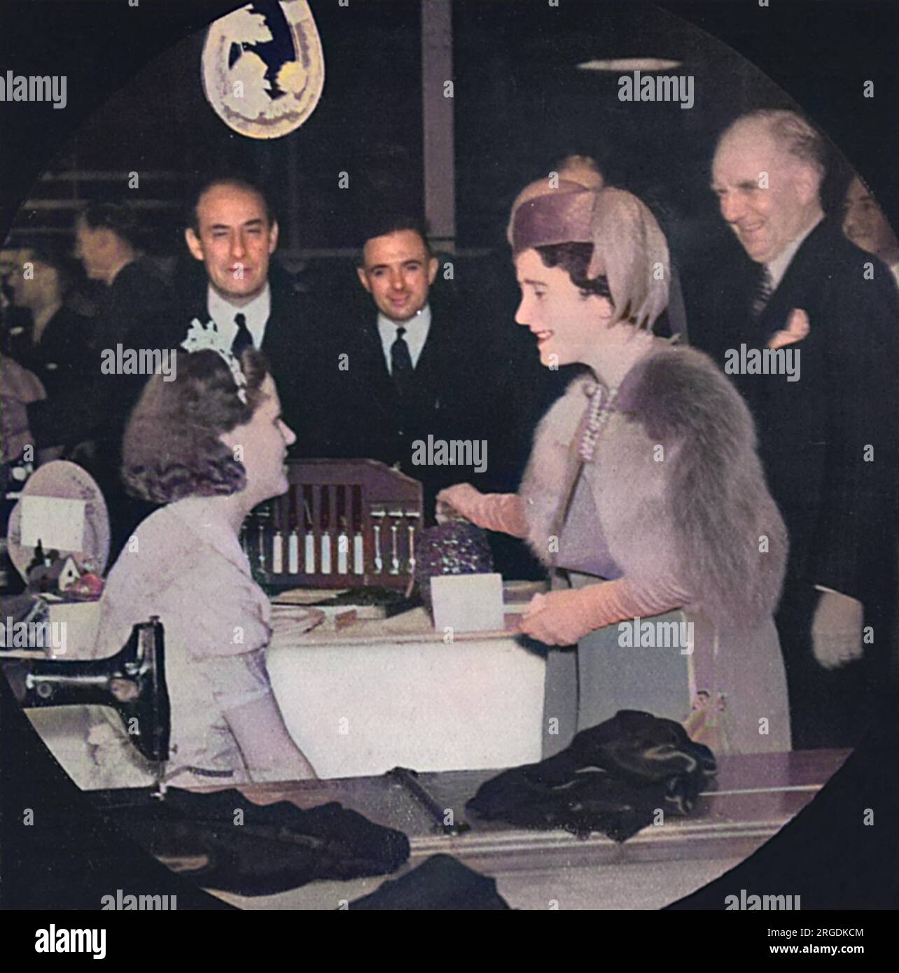 While touring a busy army clothing factory, Queen Elizabeth meets Miss ...