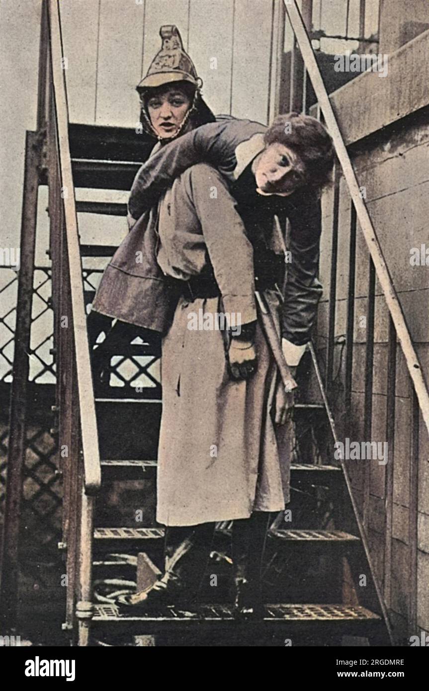A firewoman demonstrating a rescue on an iron staircase using another ...