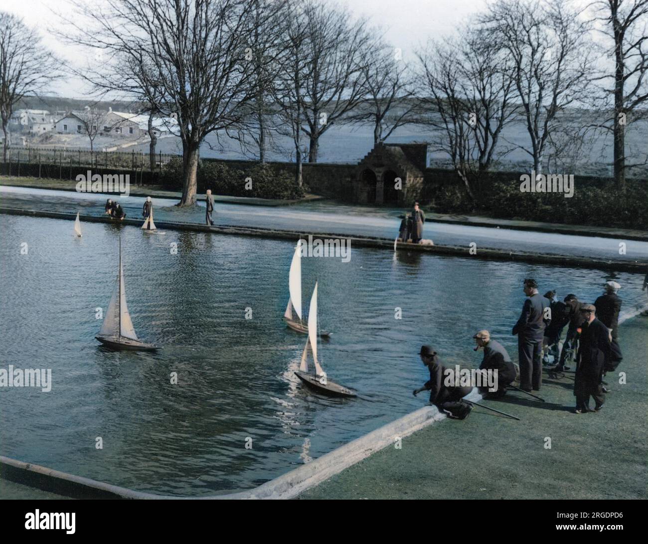 Men and boys playing with model boats on the model boating pond in ...