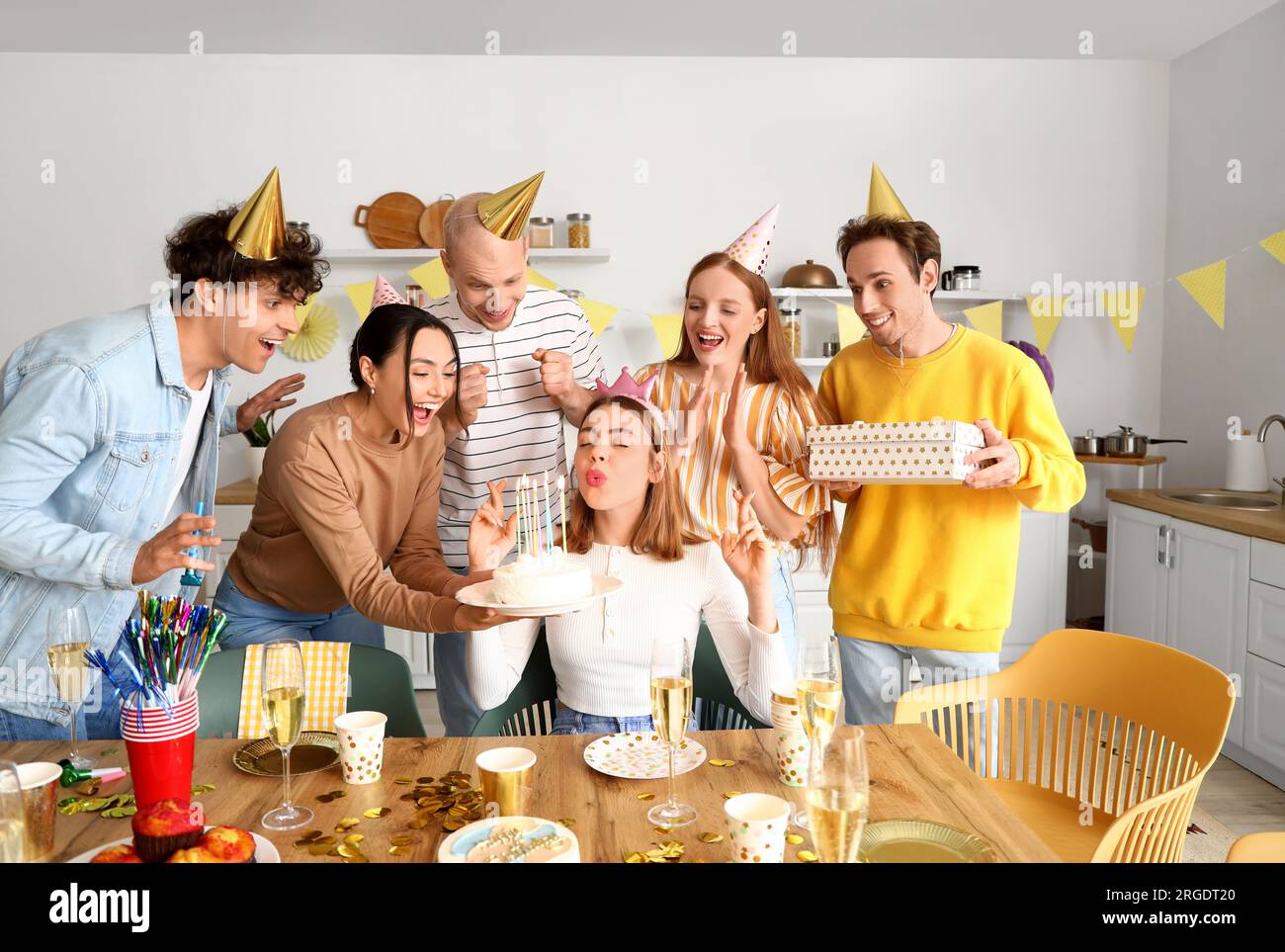 Young woman making wish at birthday party with her friends Stock Photo ...