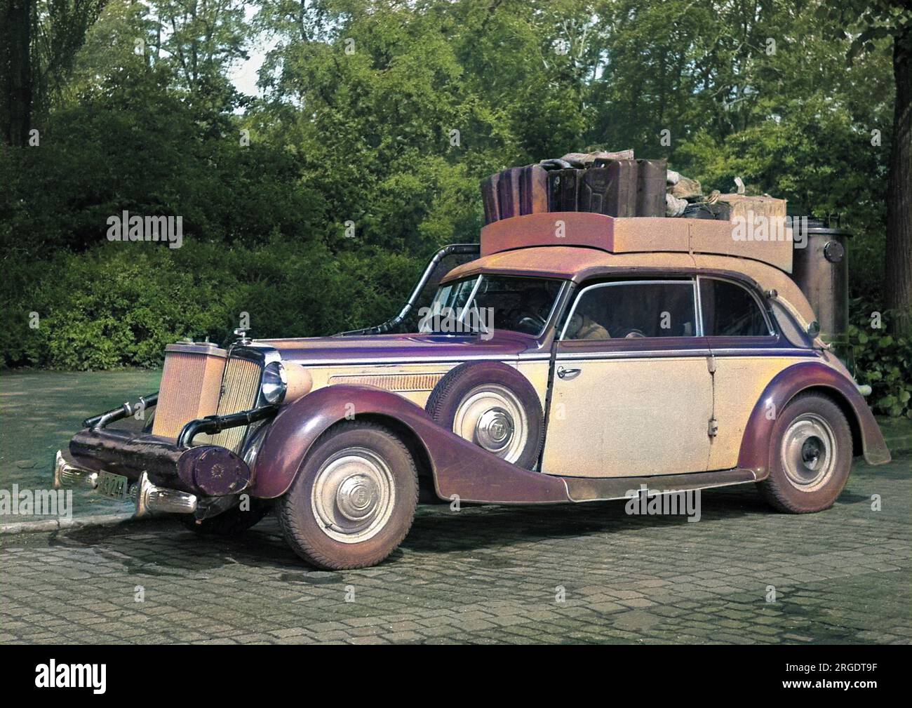 A car with several suitcases packed together on the roof rack. Note the ...
