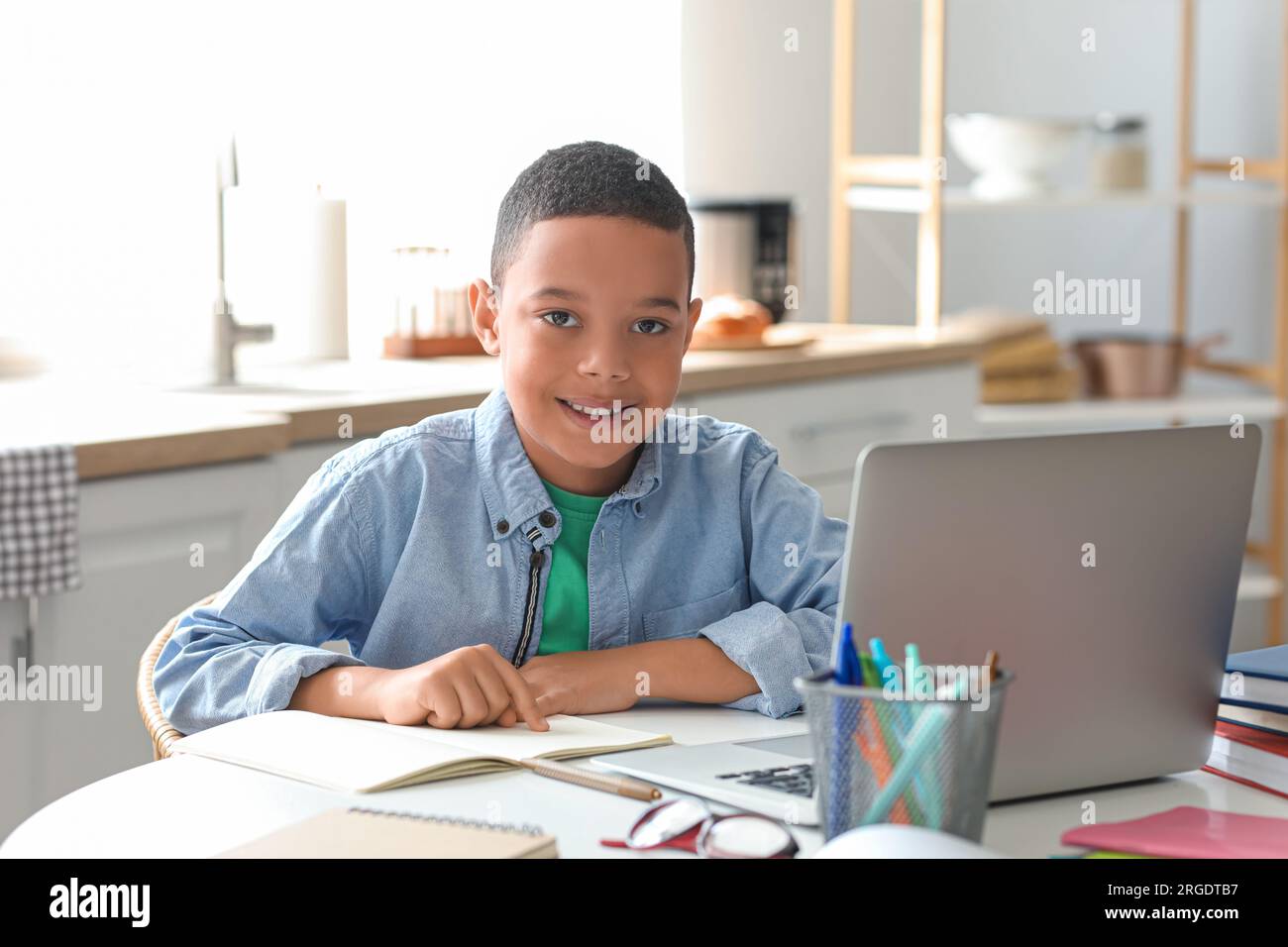 Little African-American boy studying computer sciences online in ...