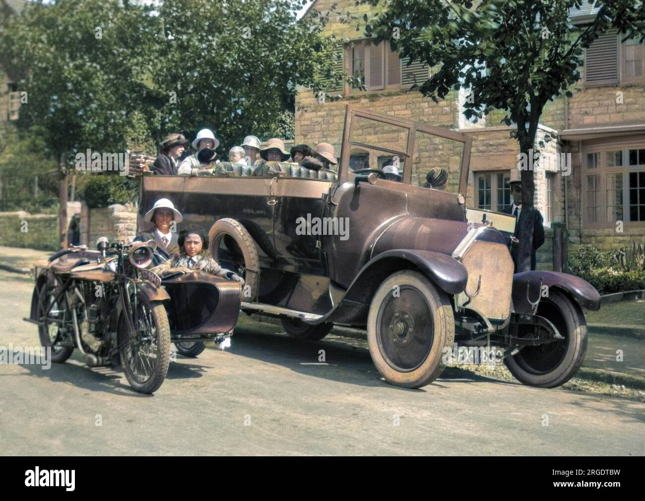 People in a charabanc and a motorcycle sidecar, ready to set off on a ...