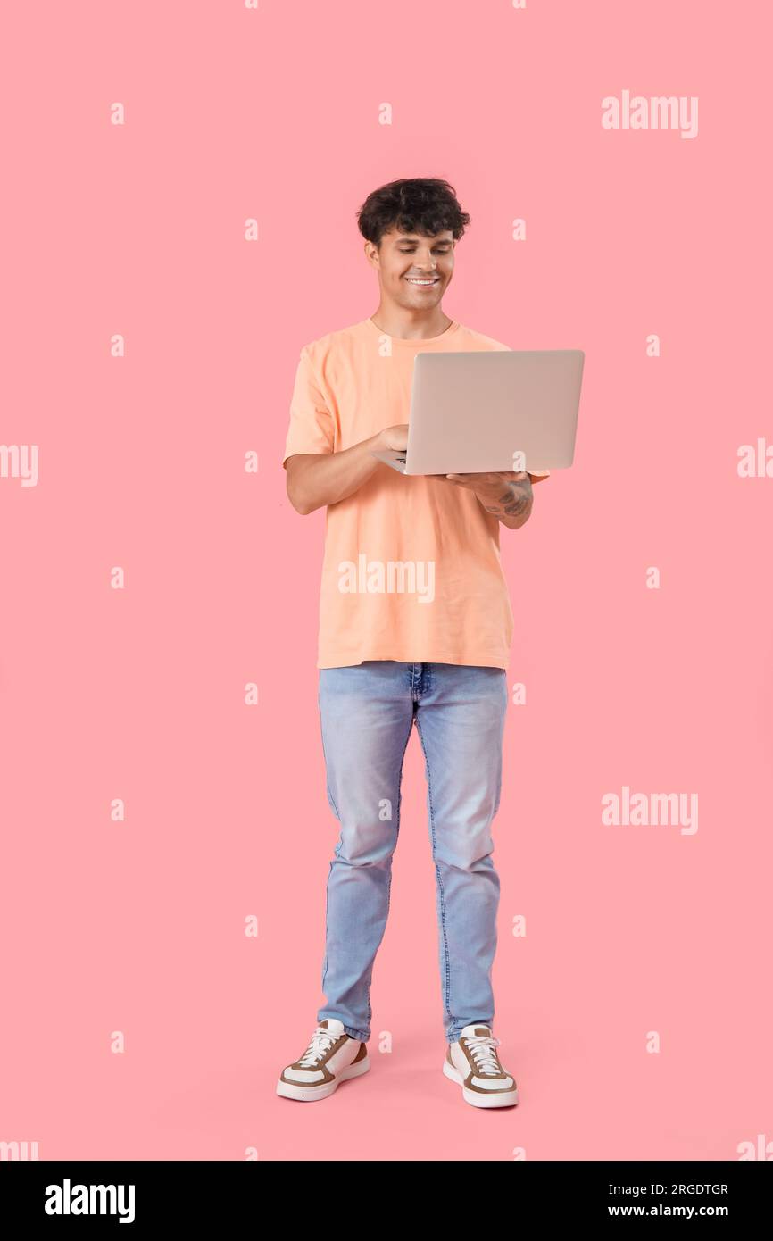 Male programmer working with computer on pink background Stock Photo ...