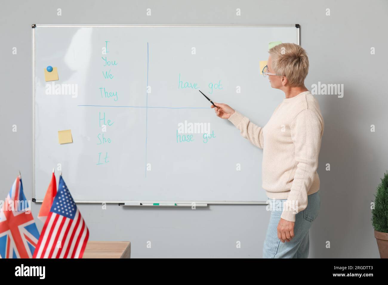 Female teacher conducting English grammar near flipboard in classroom ...