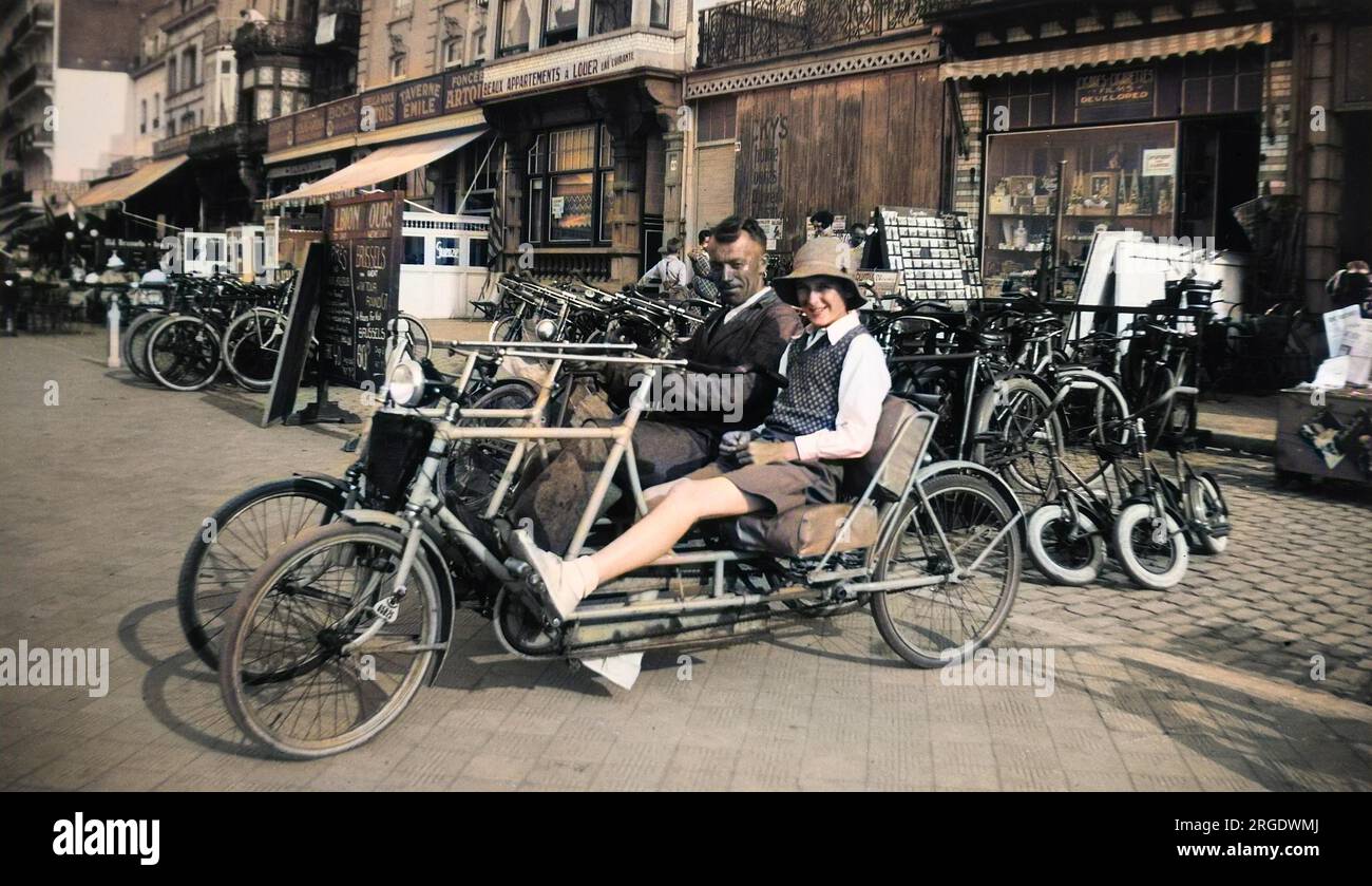 A couple on a four-wheeled two-seater cycle (also known as a velo ...