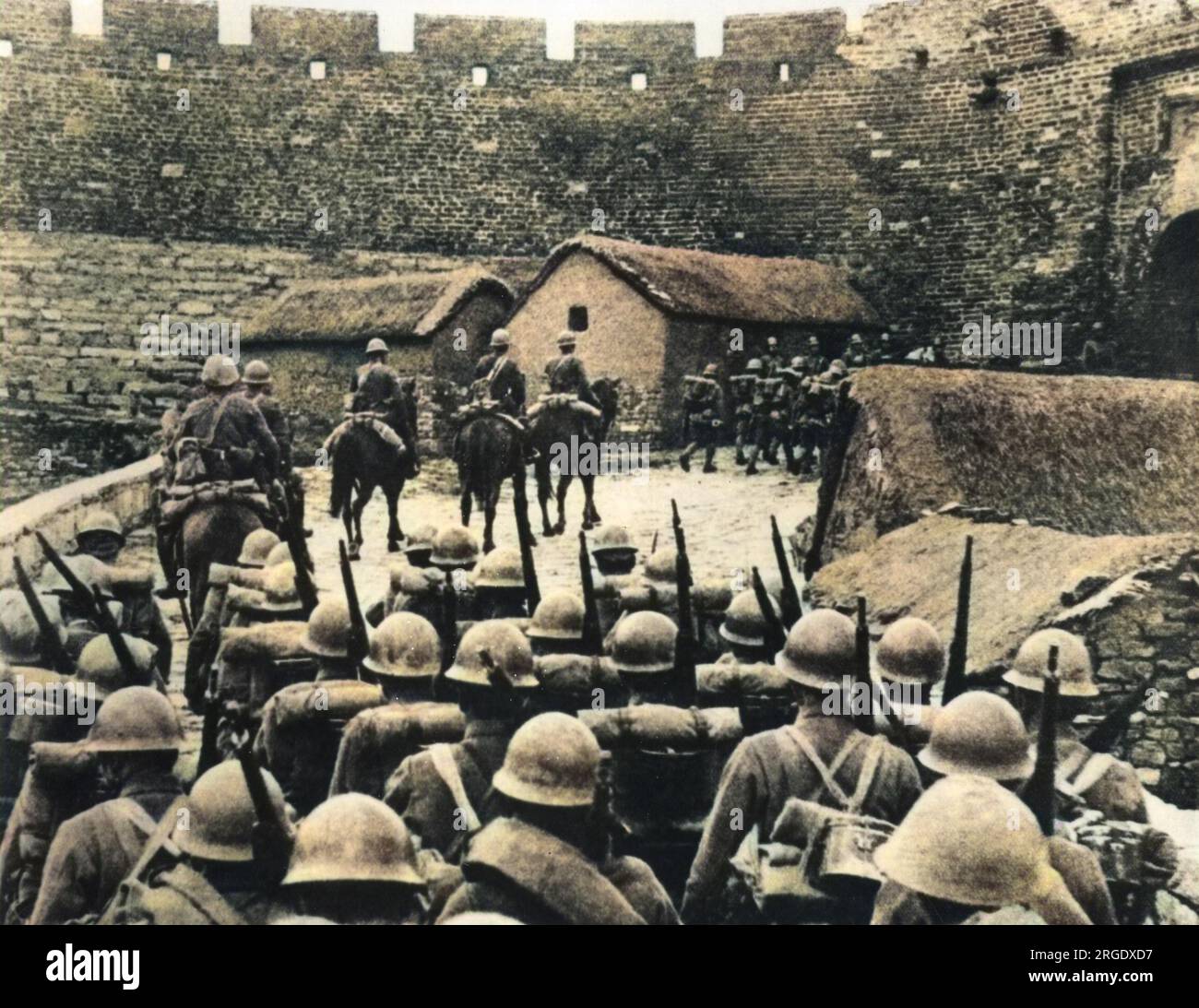 Japanese troops march into a walled town, possibly Mukden, during their ...