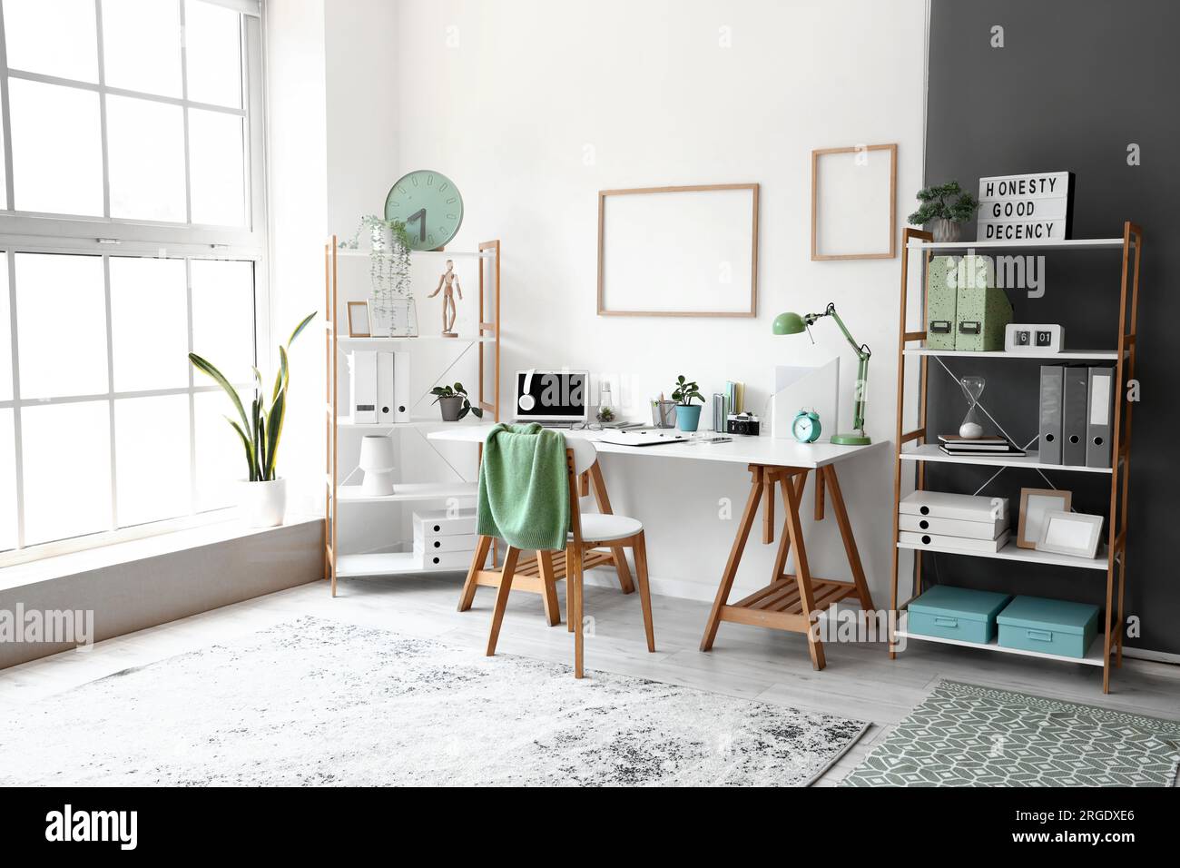 Interior of light office with workplace and shelving units Stock Photo ...