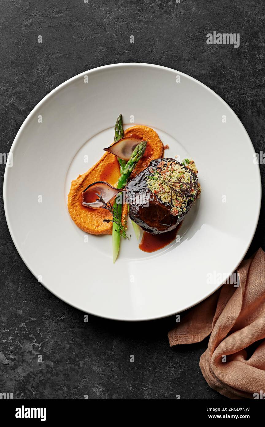 Slow-cooked beef cheek, charred shallots, asparagus spears, romesco ...