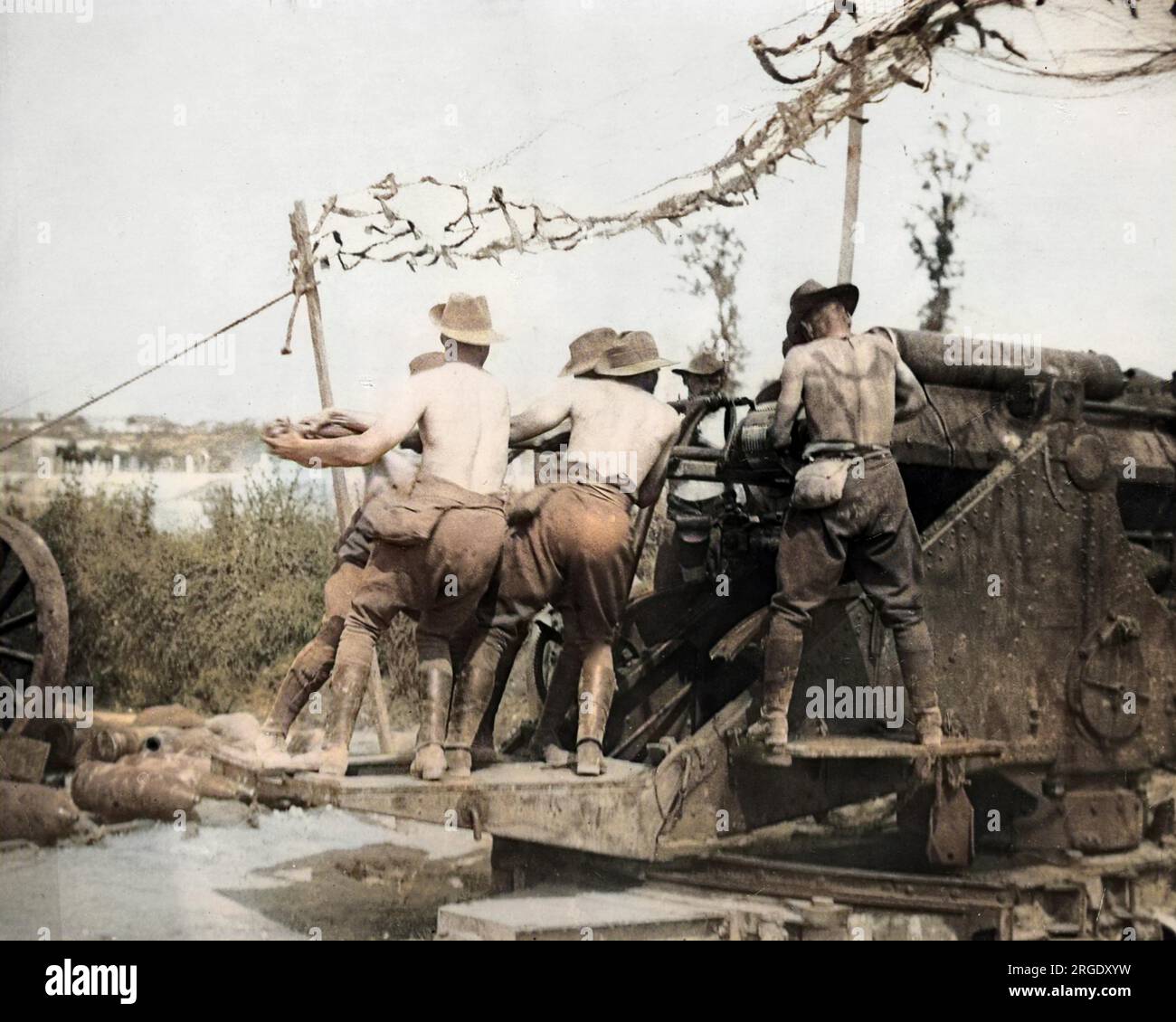 Australian gunners loading a shell into a big gun during hot weather on ...