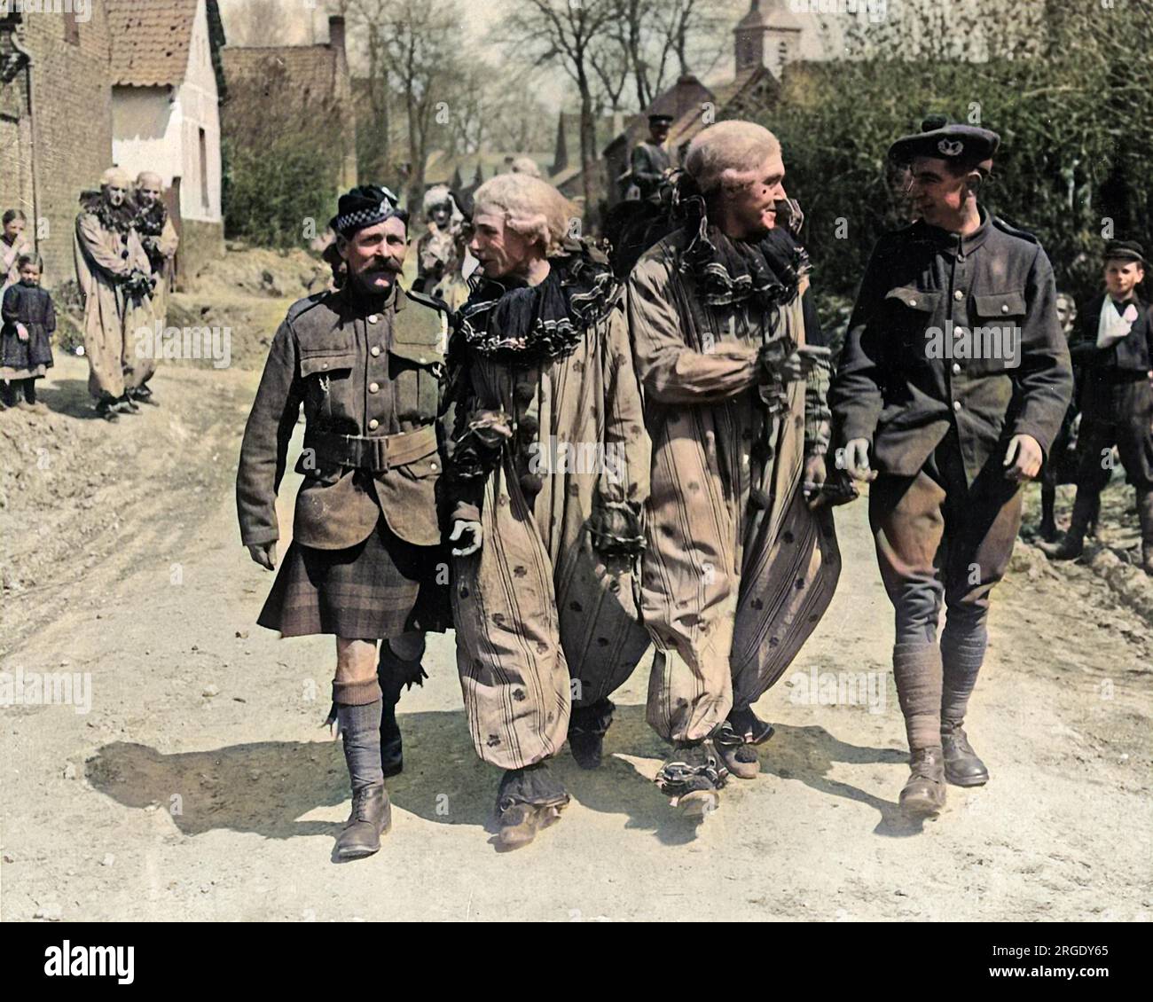 Two entertainers in costume, walking along a road with Scots soldiers ...