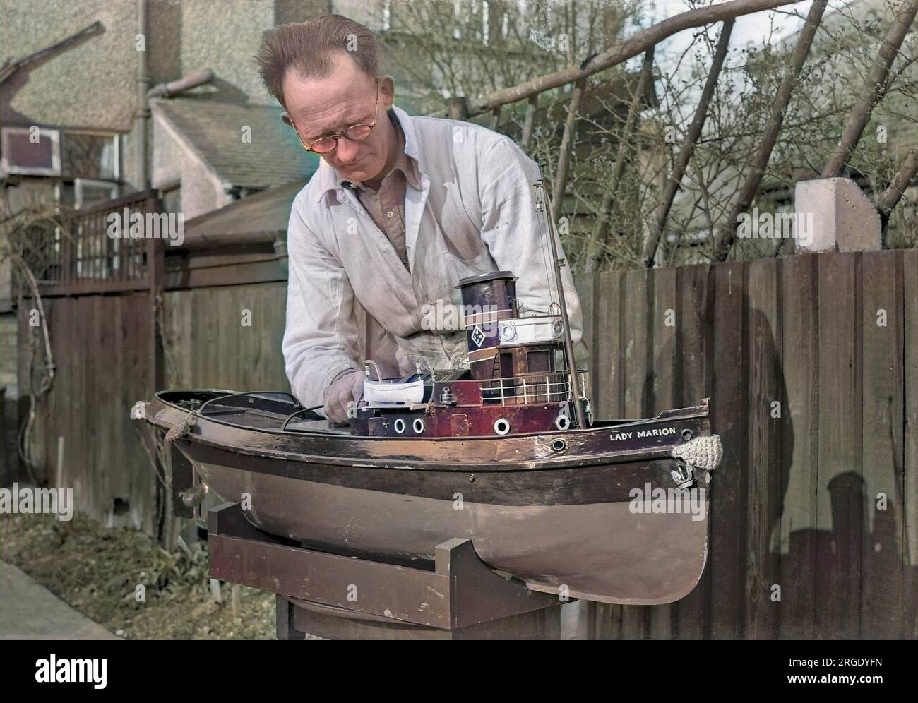 A man making a model boat, Lady Marion, in a back garden Stock Photo ...