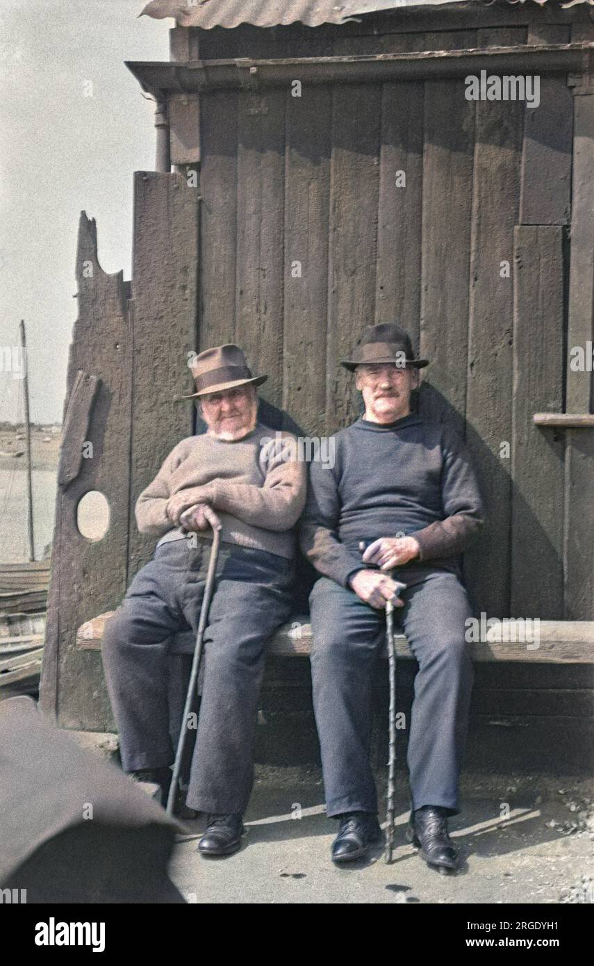 Two men with walking sticks, relaxing on a bench in the sunshine Stock ...