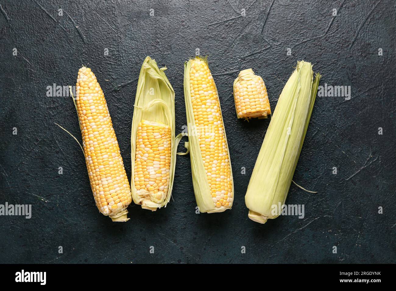 Fresh corn cobs on black background Stock Photo - Alamy
