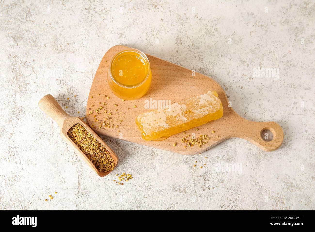 Wooden board with jar of honey, comb and bee pollen on light background ...