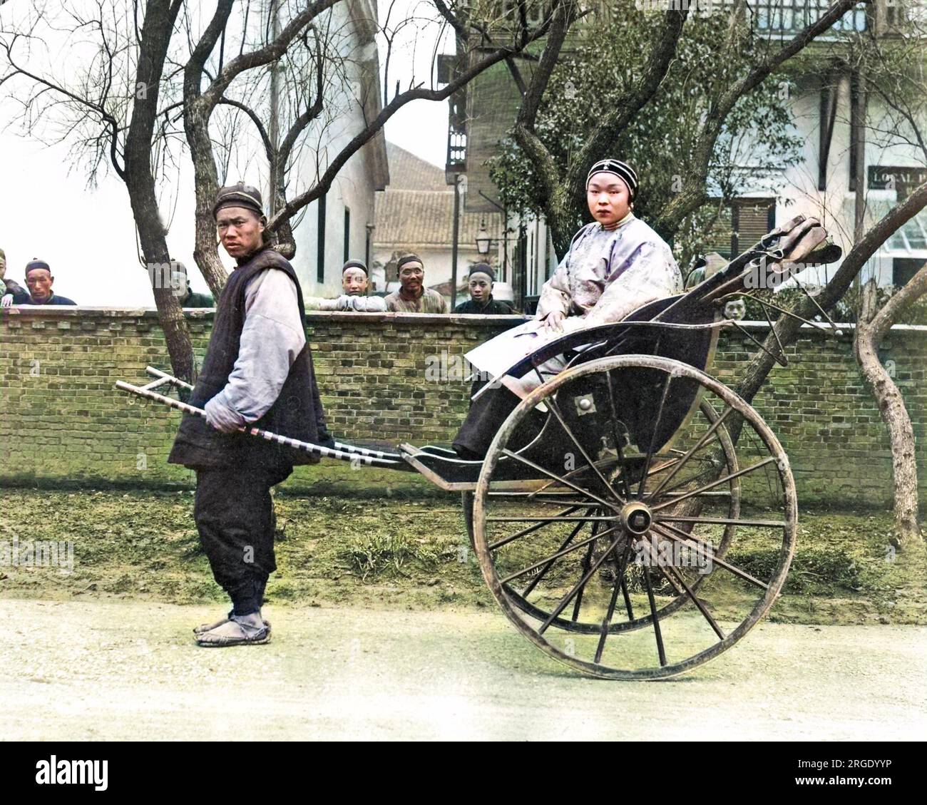 Woman in a rickshaw, China, with people watching from behind a wall ...