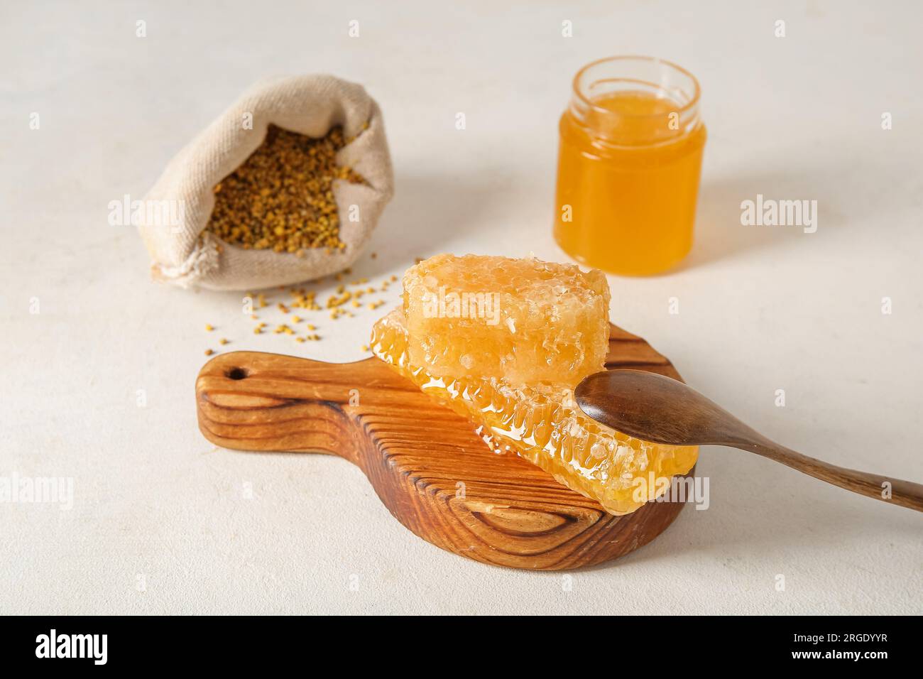 Jar of tasty honey, combs and bee pollen on light background Stock ...