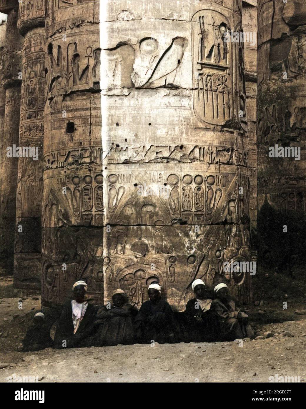 Men sitting at the base of a column, Karnak, Egypt Stock Photo - Alamy