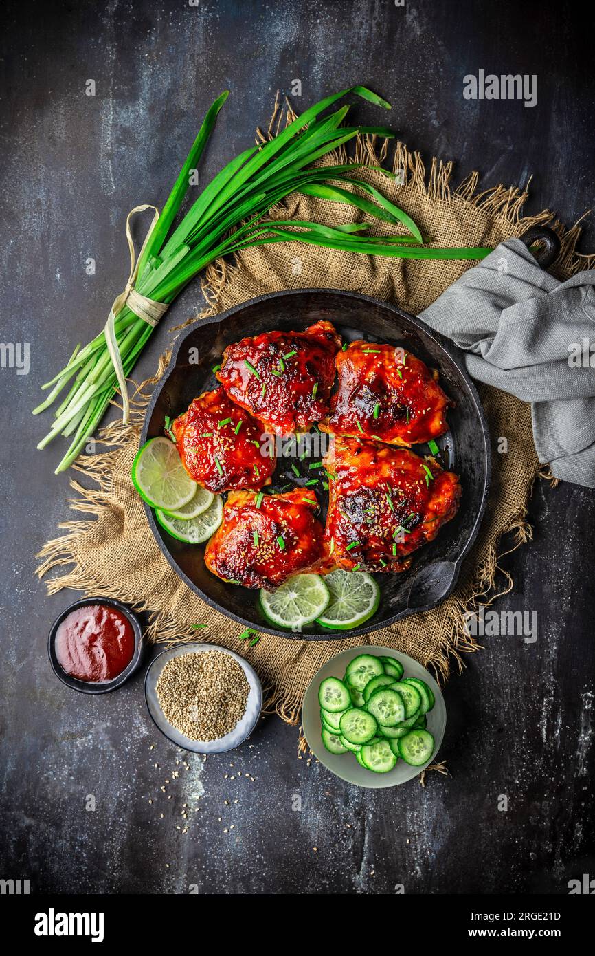 Vintage cast iron pan with spicy glazed chicken thighs with sauce ...
