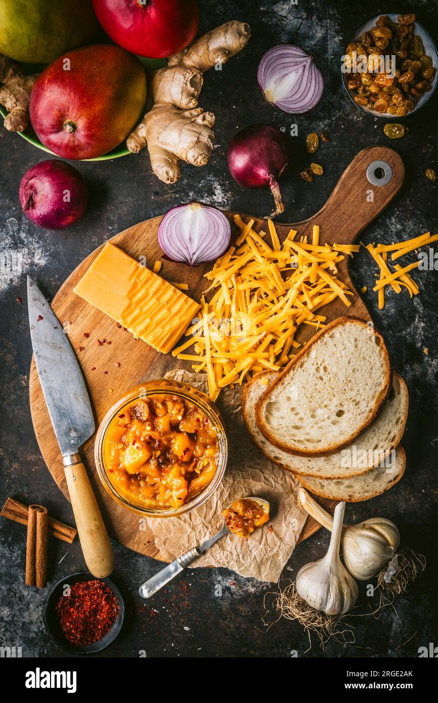 Rustic board with grated cheese, bread mango chutney and ingredients ...