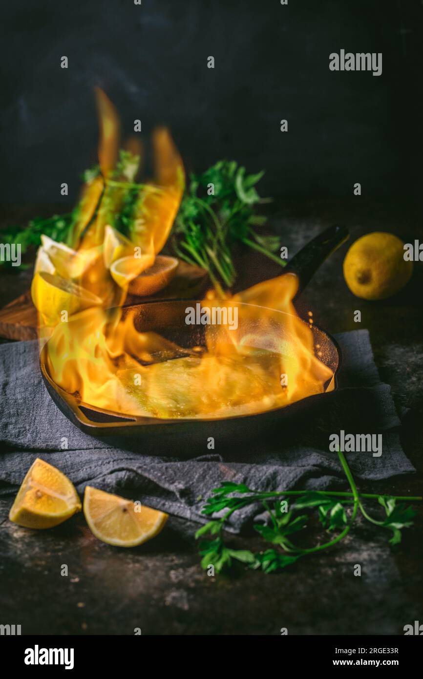 Cheese Flambé with large flame in cast iron skillet with parsley and ...