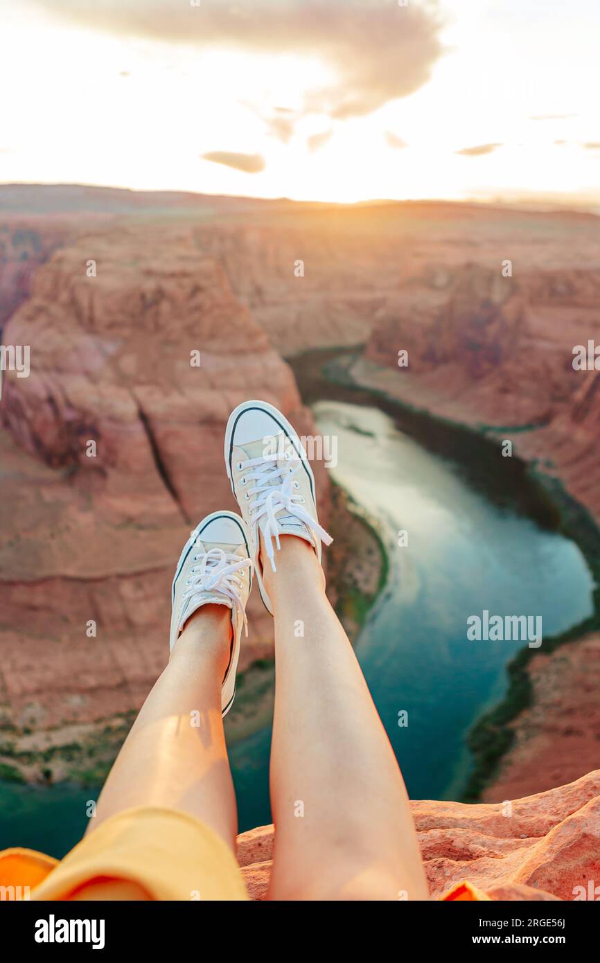 Legs on the edge of the cliff at Horseshoe Band Canyon in Page, Arizona ...