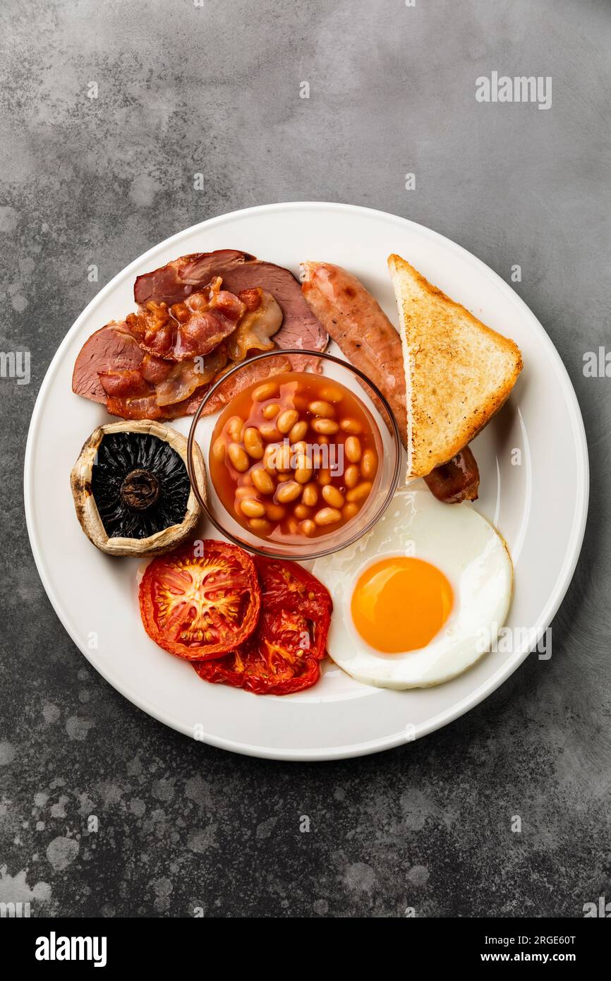 Full fry up English breakfast with fried eggs, sausages, bacon, beans ...