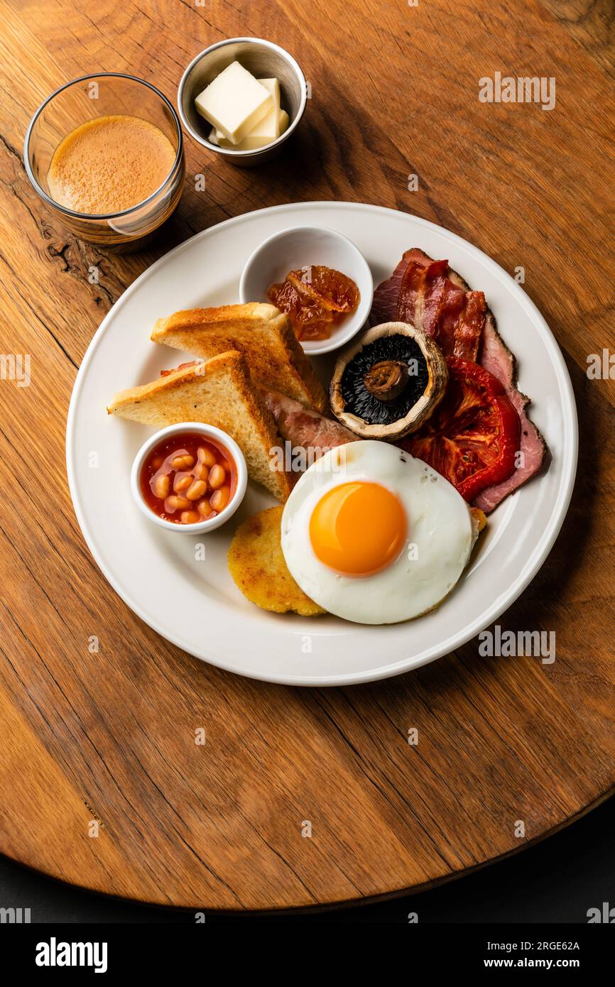 Full fry up English breakfast with fried eggs, sausages, bacon, beans ...