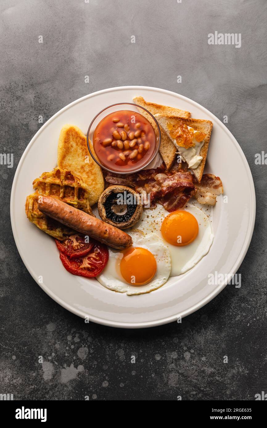 Full fry up English breakfast with fried eggs, sausages, bacon, beans ...