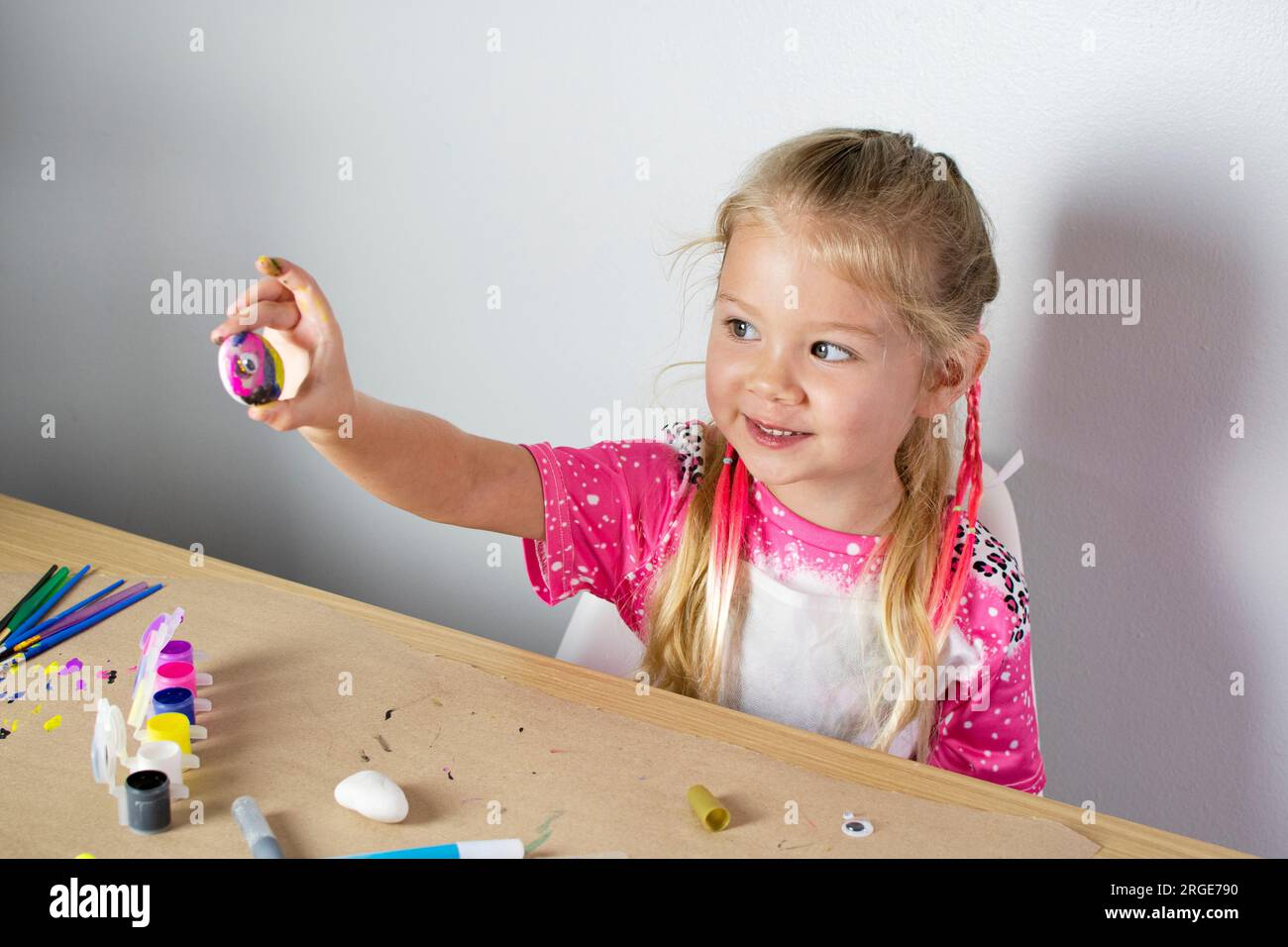 Cute Caucasian preschool girl is showing an art she made. Painting ...