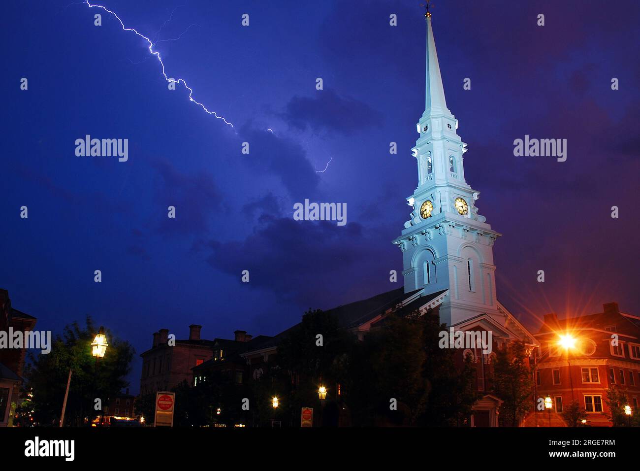A lightning bolt flashes across the sky near a historic church with an ...