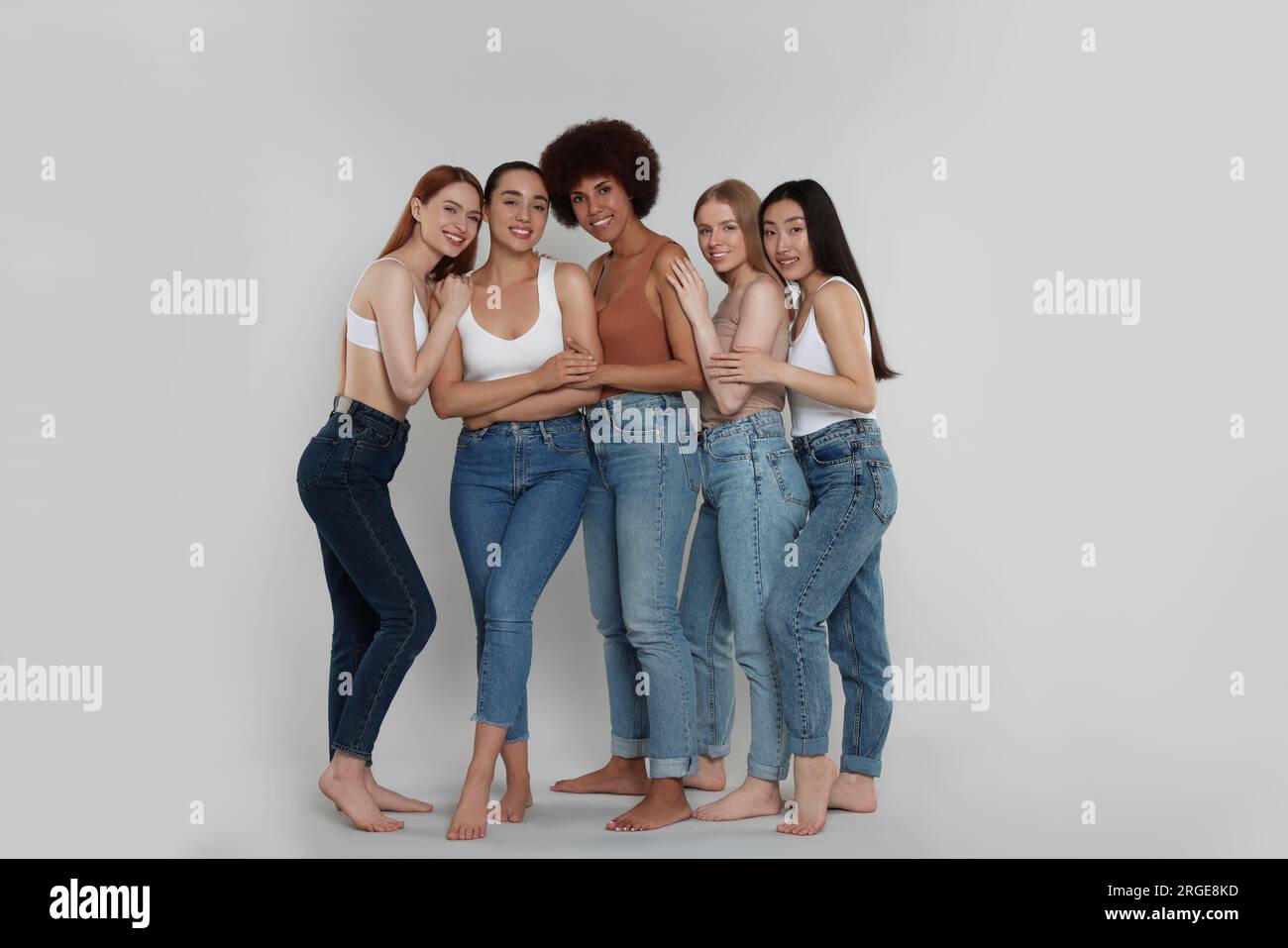 Group of beautiful young women on light grey background Stock Photo - Alamy