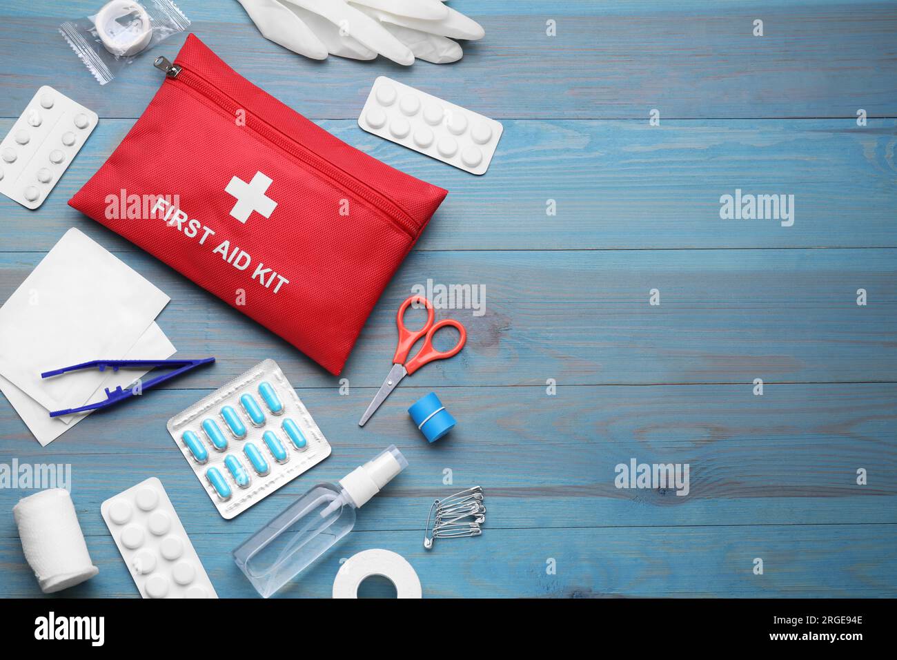Flat lay composition with first aid kit on blue wooden table, space for ...