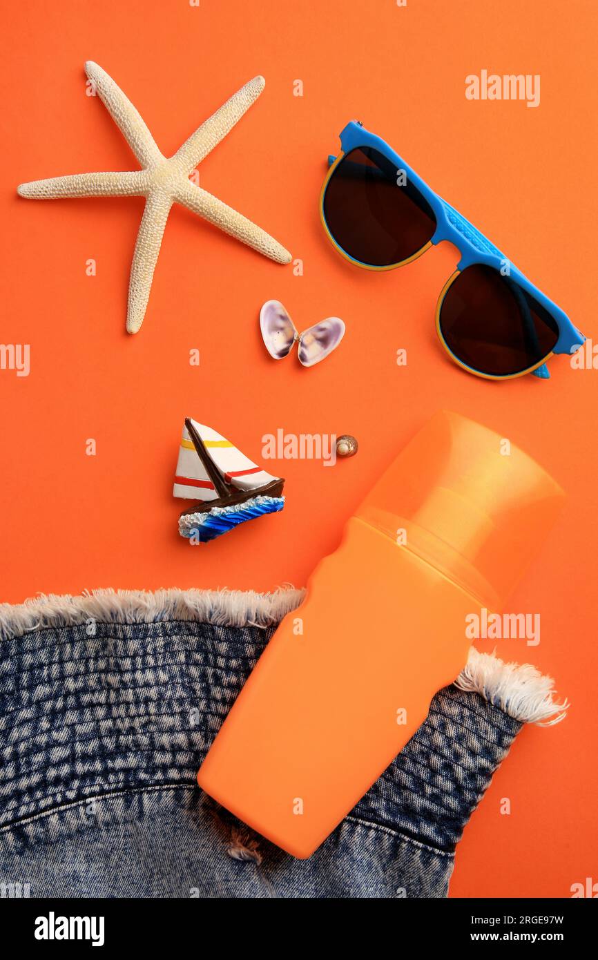 Flat lay composition with bottle of sunscreen on coral background Stock ...