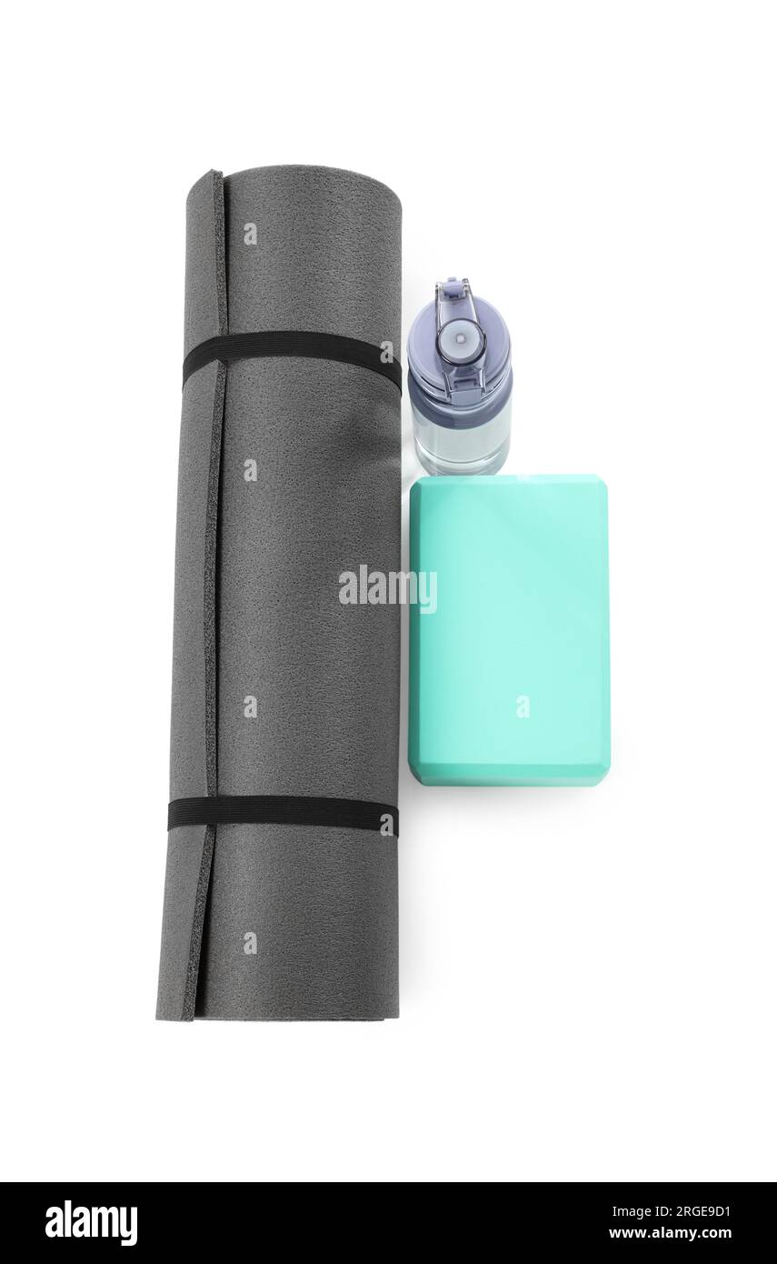 Grey exercise mat, yoga block and bottle of water isolated on white ...
