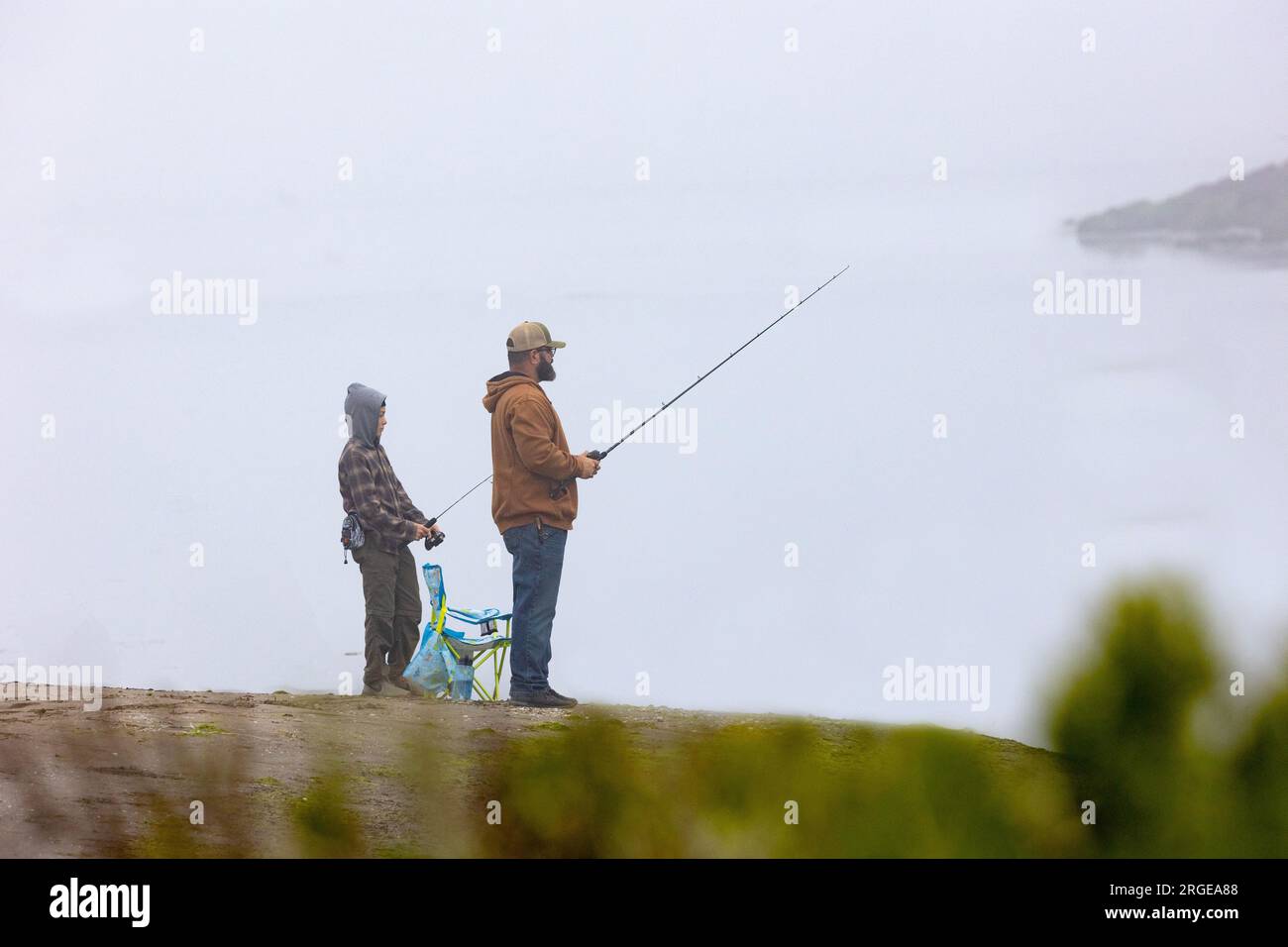 Father and Son Fishing from Shoreline Stock Photo - Alamy
