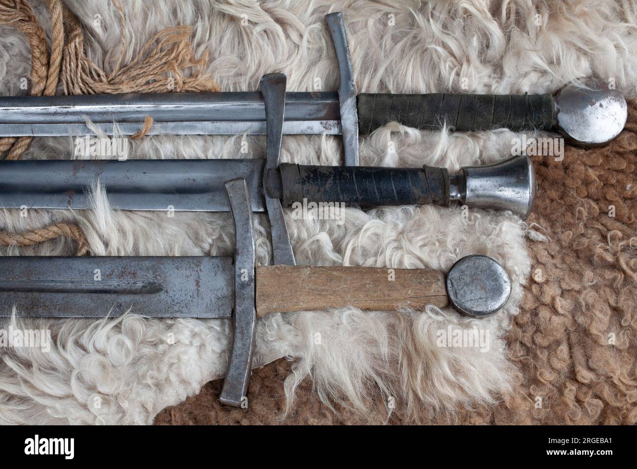 Medieval swords on sheep fur background Stock Photo - Alamy