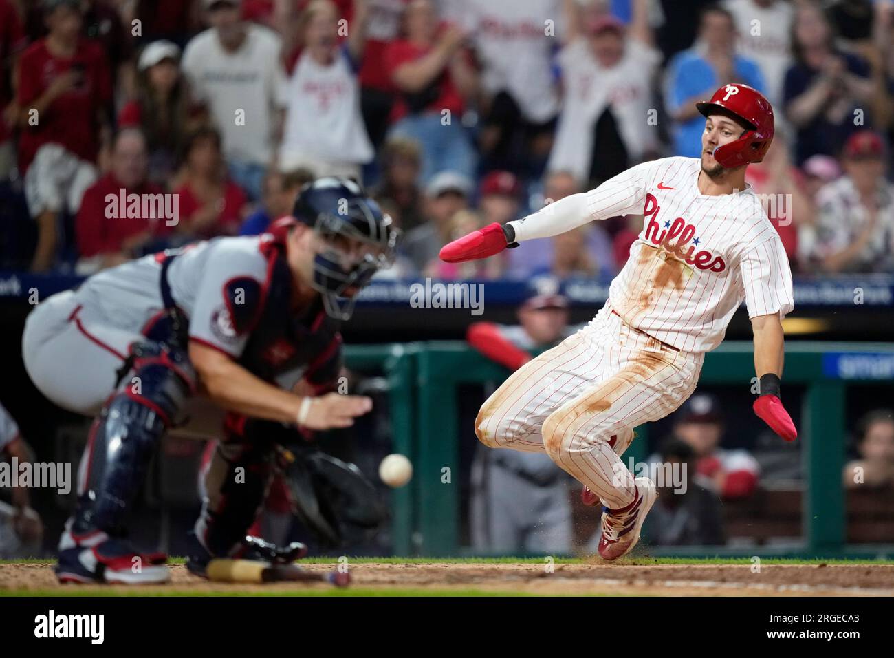 Philadelphia Phillies' Trea Turner, right, slides past Washington Nationals catcher Riley Adams ...