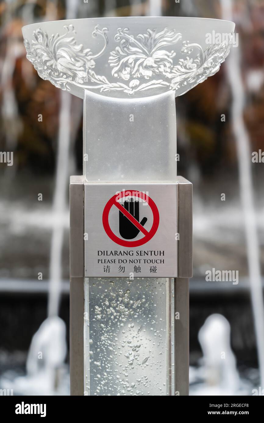 Close-up view of the "Please do not touch" sign with the water fountain ...
