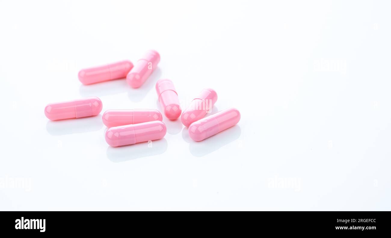 Pink capsule pills on white background. Pharmaceutical industry ...