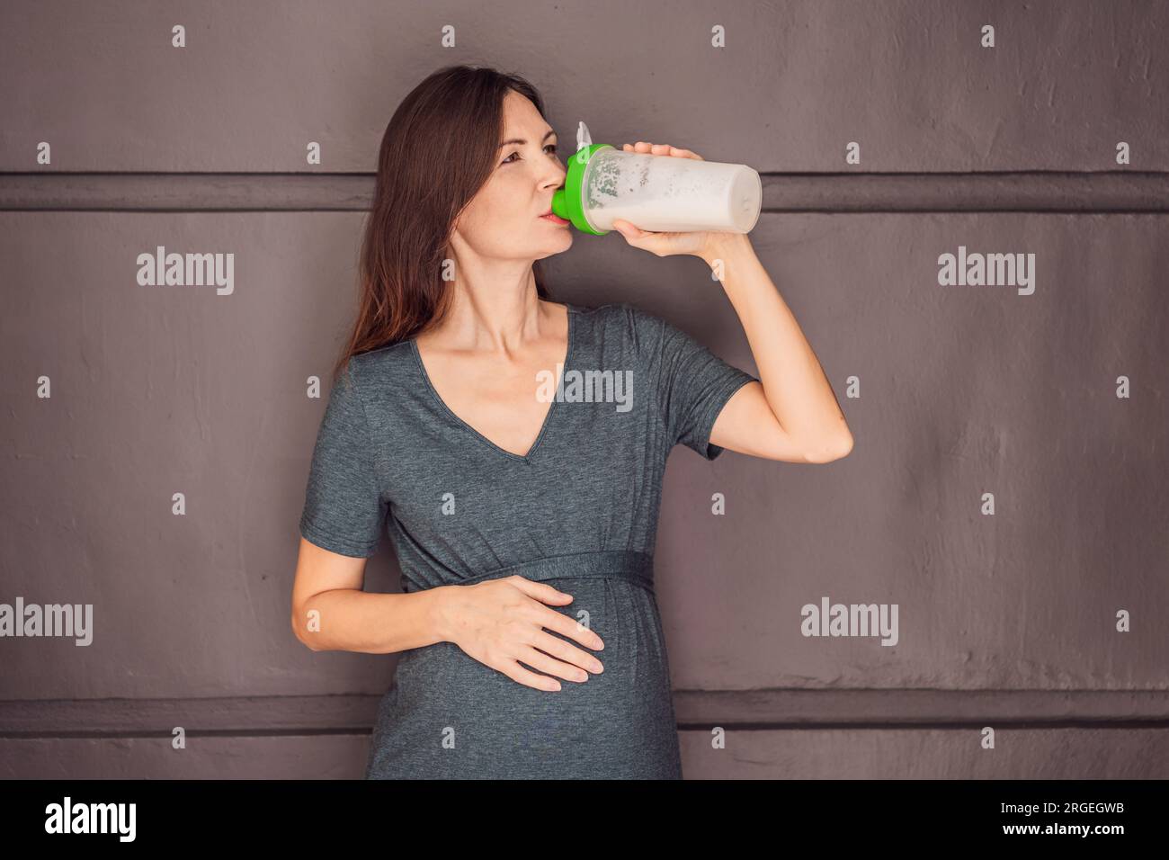 Energetic and fit pregnant woman after 40 enjoying a protein shake for ...