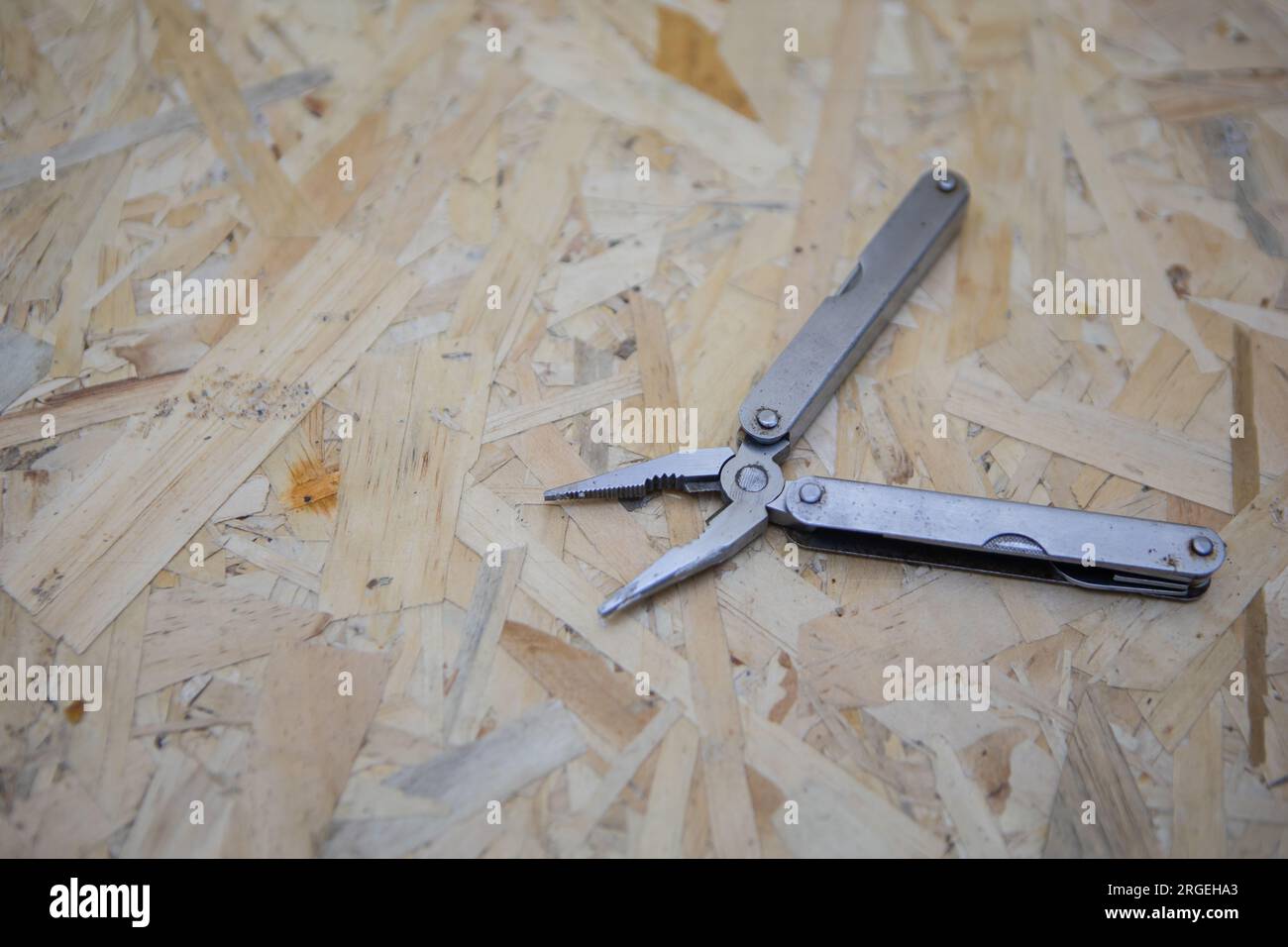 Silver all purpose pocket knife on a rustic wooden background. Top view ...