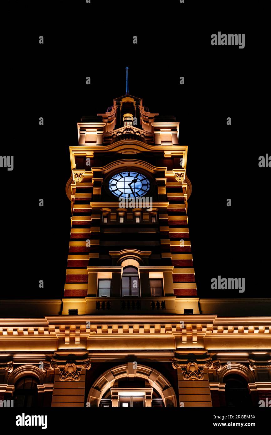 Symmetrical clock tower at night Stock Photo - Alamy