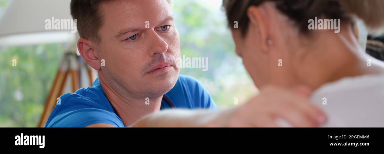 Male doctor puts hand on patient shoulder and speaking about medical ...