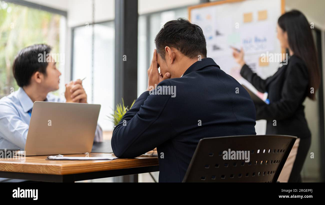 A stressed Asian businessman is in the meeting, worried and upset about ...