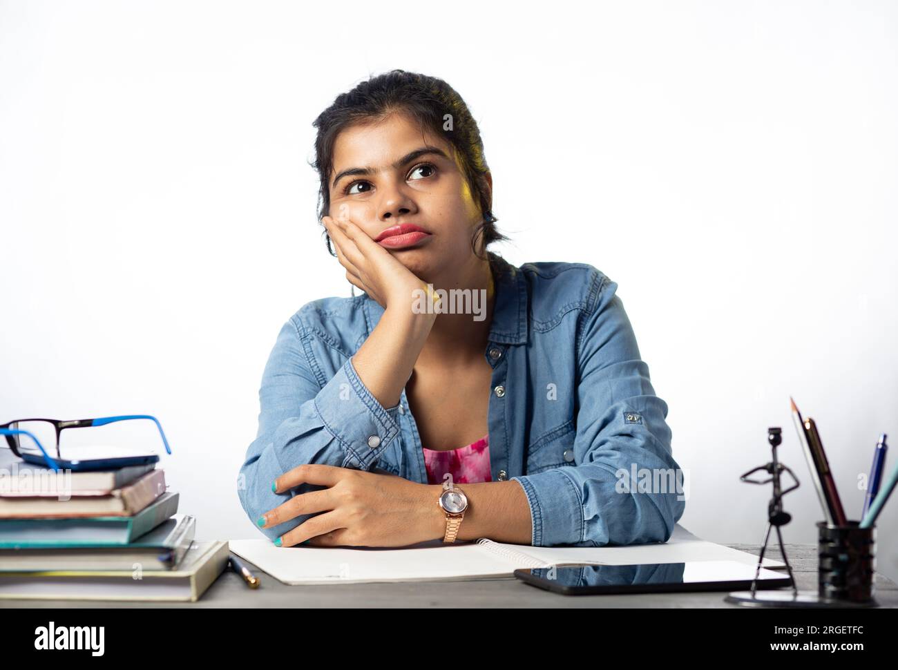 A pretty young Indian college student thinking while studying n study ...